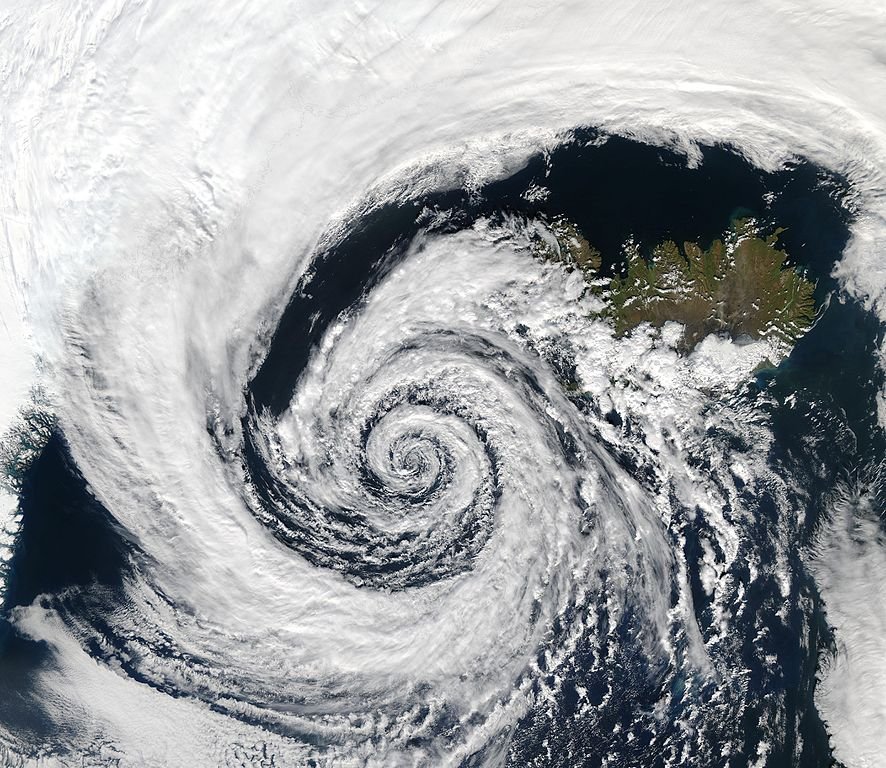 How does the Coriolis force determine the spin of a cyclone?